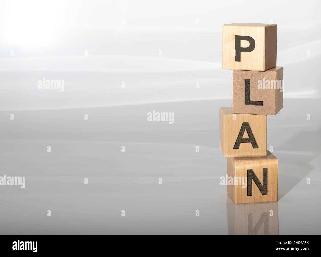 PLAN word on wooden cubes on white grey glossy background with ...