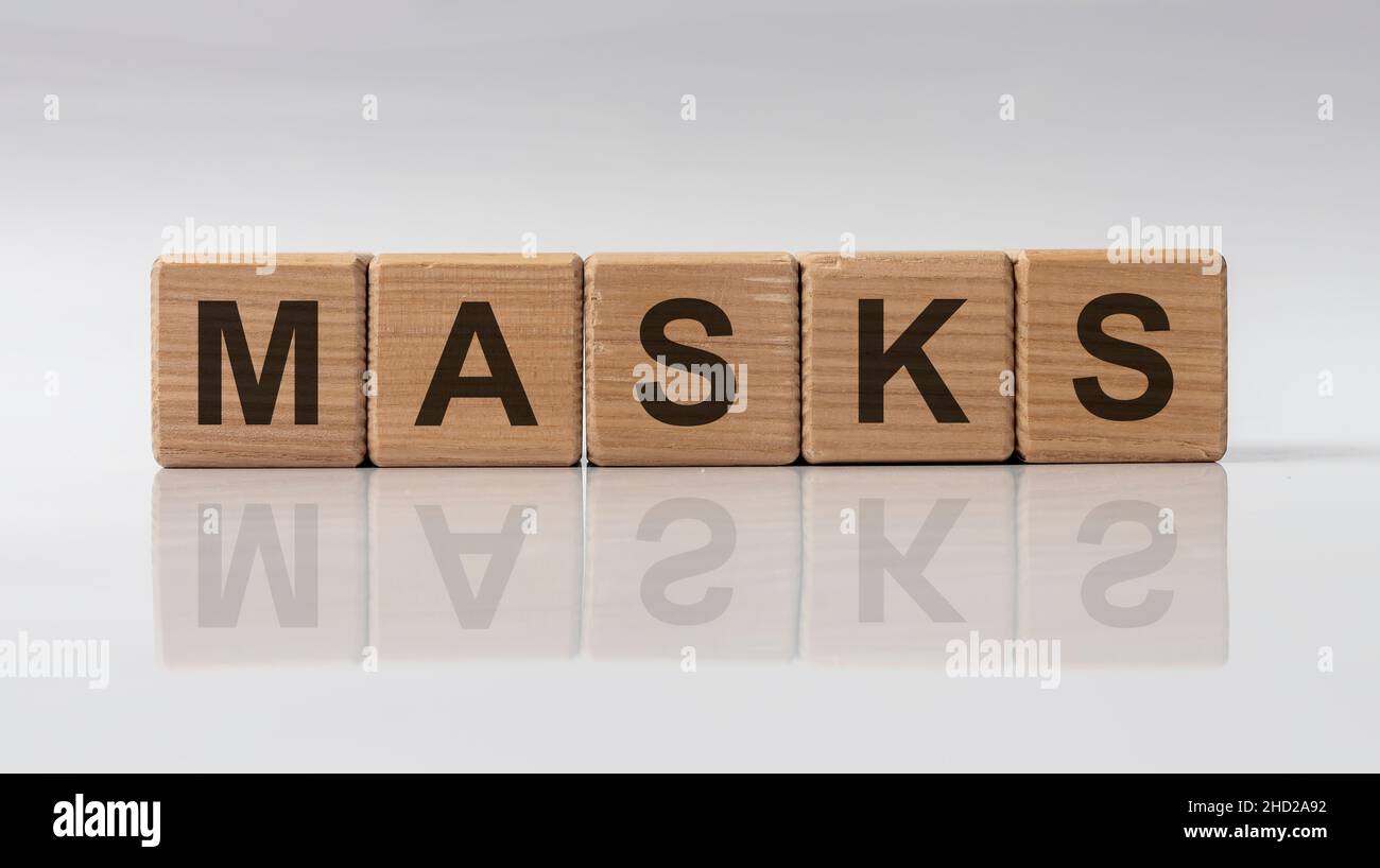 Word masks written with wooden blocks laying on white grey glossy ...