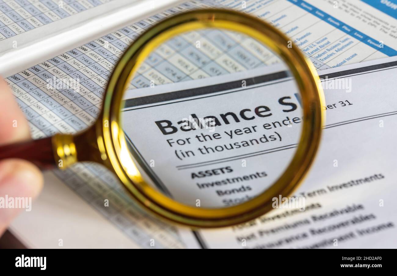 balance sheet word through a magnifying loupe on the background of a ...