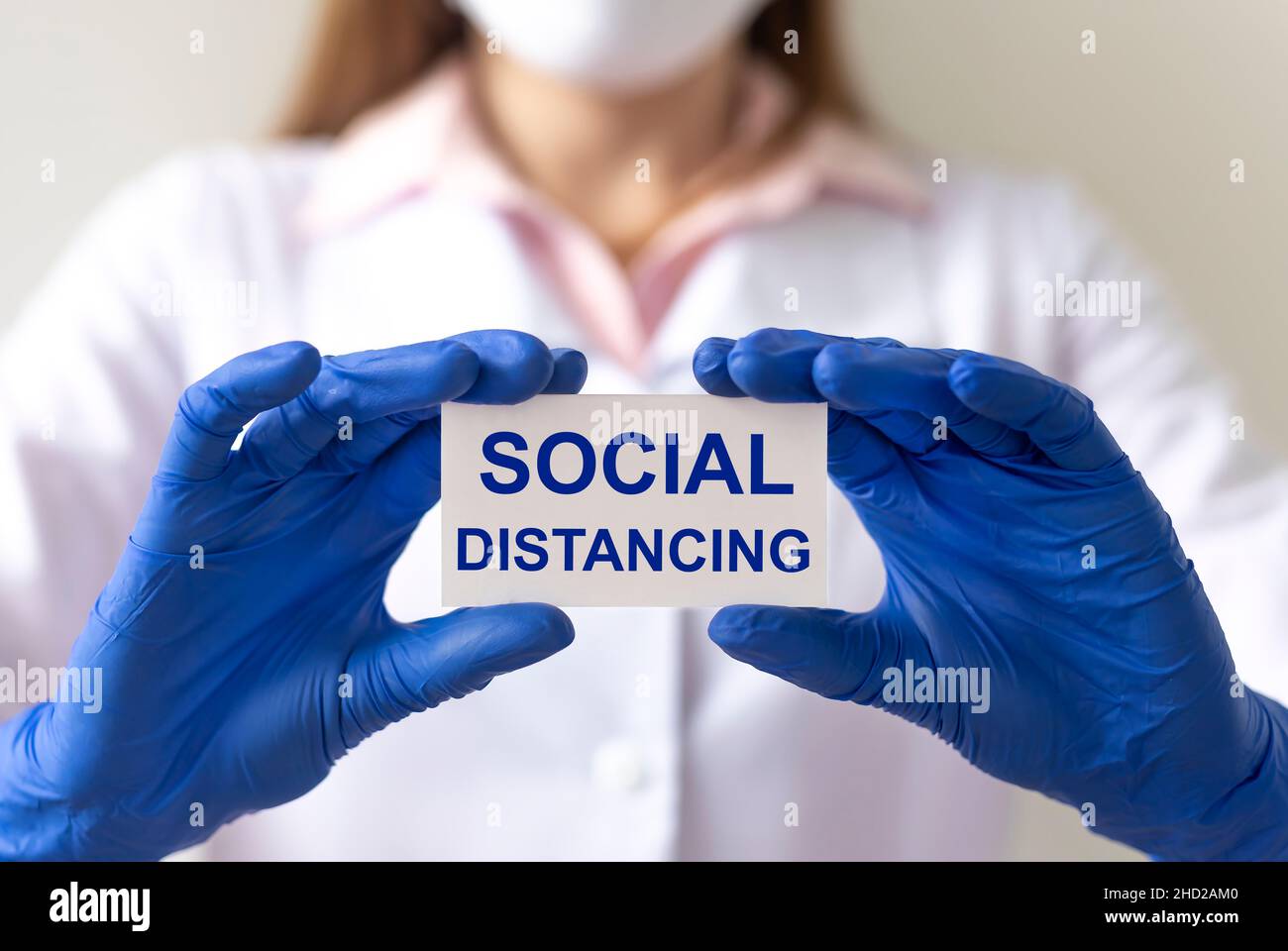 Social distancing text on a paper in doctor hands Stock Photo - Alamy