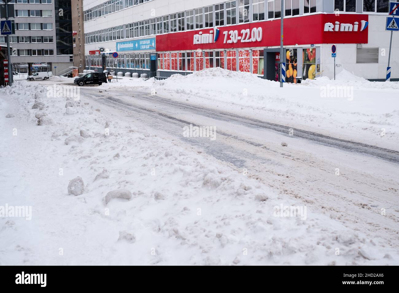 Difficult weather conditions. Street and sidewalk under snow piles ...
