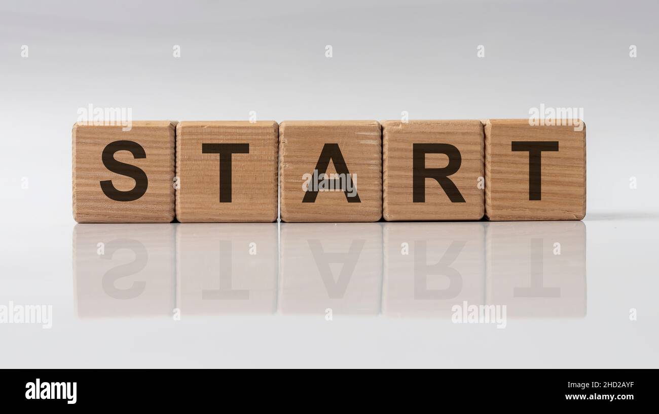 Word START made with wooden cubes, white background with reflection ...