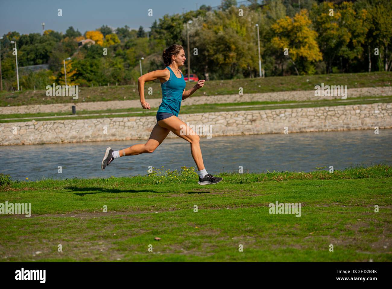 Attractive and beautful fit girl is running fast and hard by the river ...