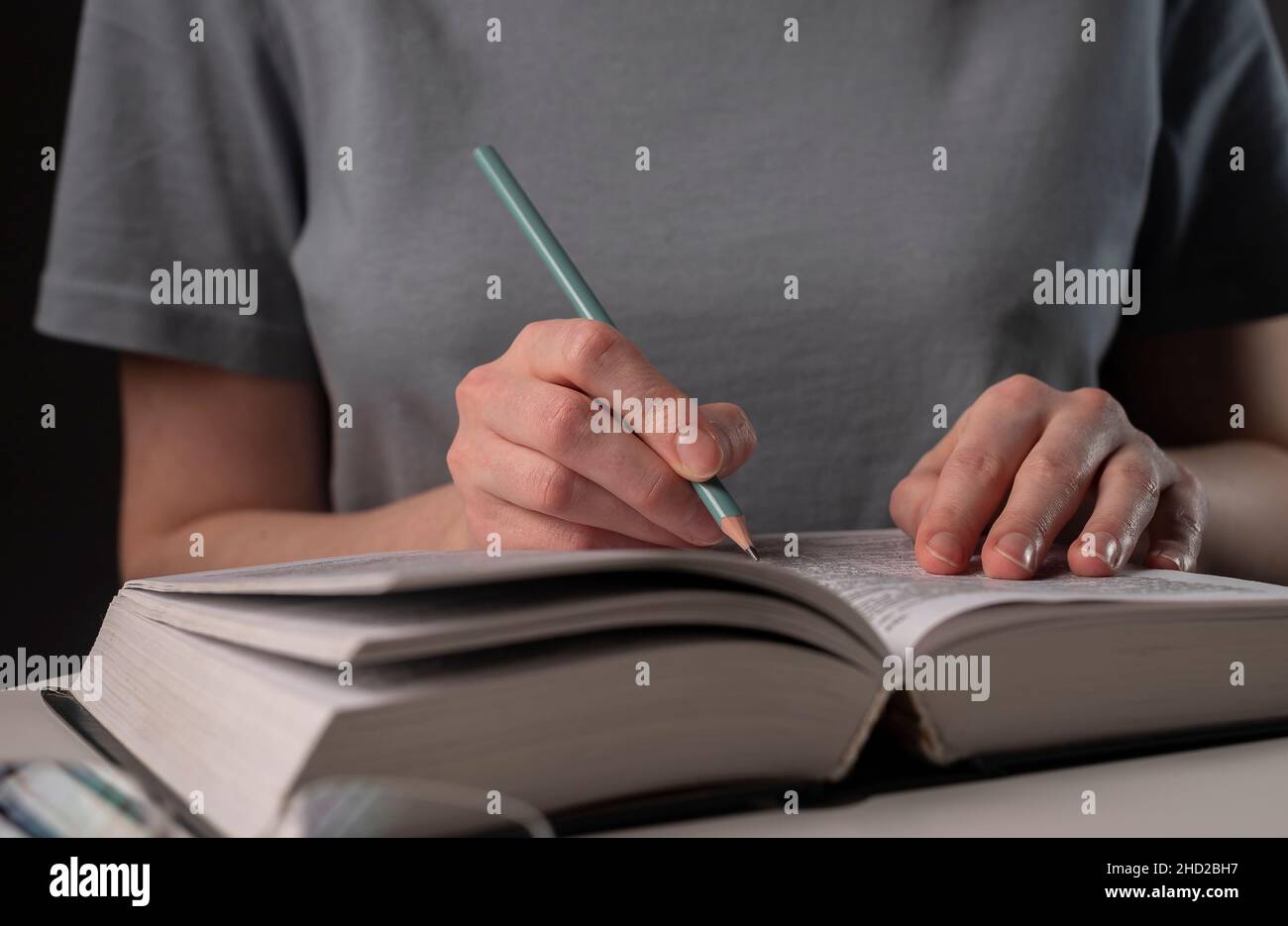 Female student hands holding pencil and reading book, prepare for exam ...