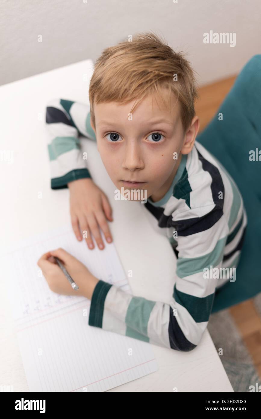 School boy practicing writing the alphabet at home. Boy child kid ...