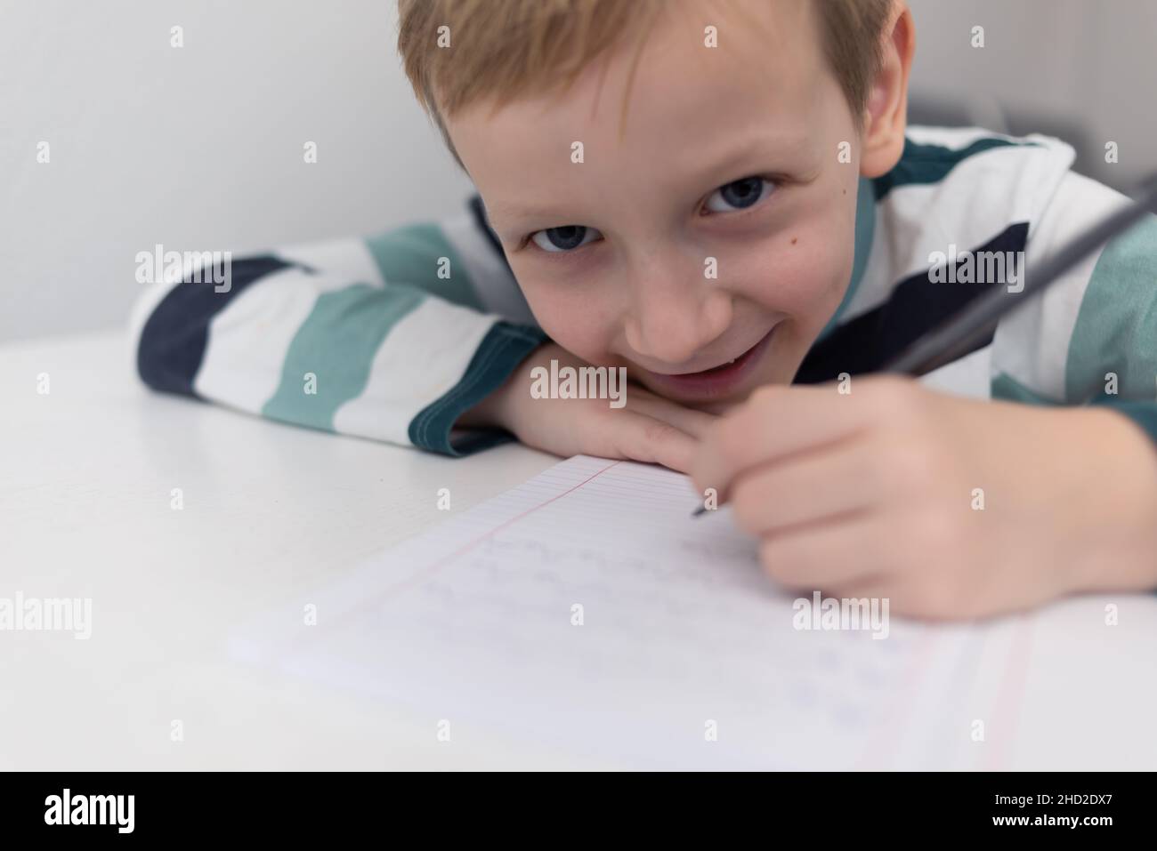 School boy practicing writing the alphabet at home. Boy child kid ...