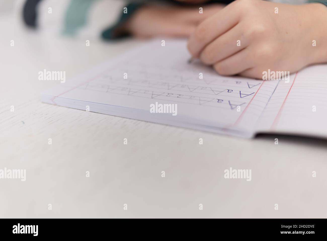 School boy practicing writing the alphabet at home. Boy child kid ...