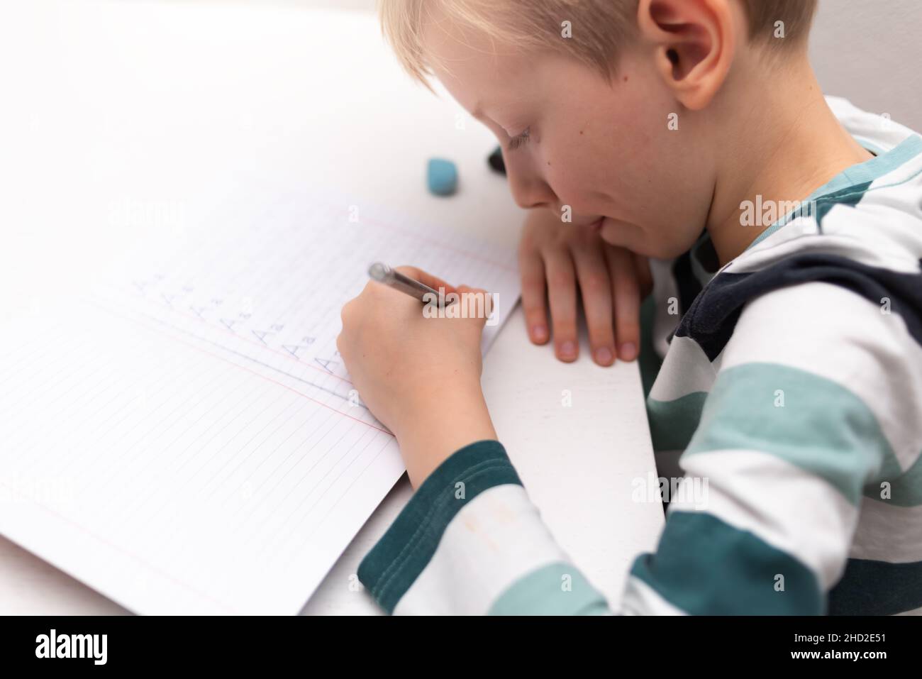 School boy practicing writing the alphabet at home. Boy child kid ...
