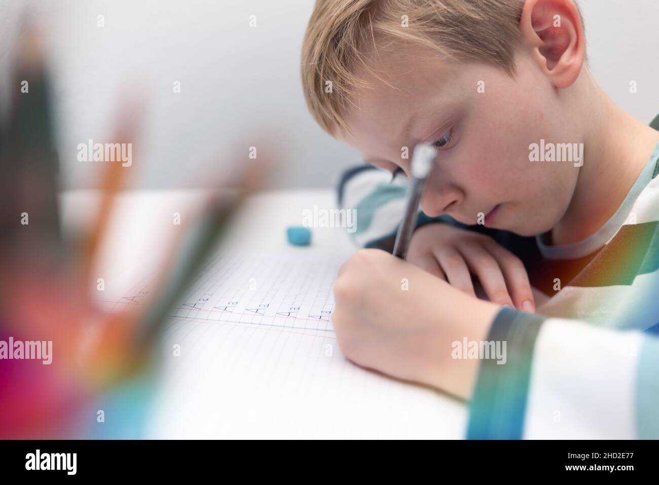 School boy practicing writing the alphabet at home. Boy child kid ...