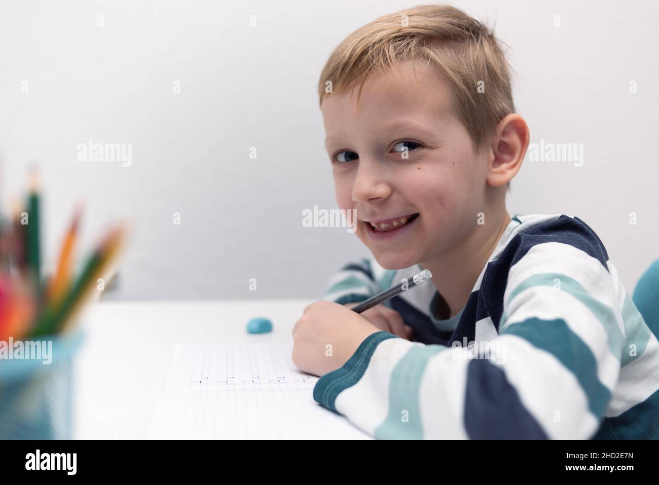 School boy practicing writing the alphabet at home. Boy child kid ...