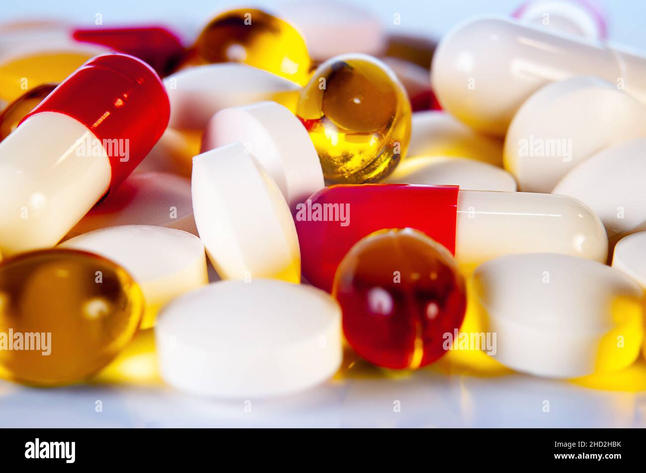 different kind of pills, tablets and capsules on light blue background ...