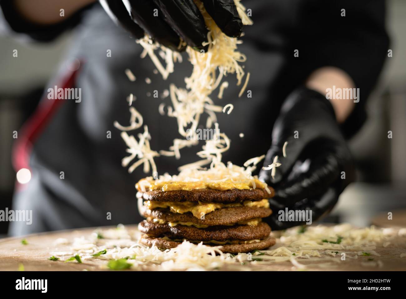 the chef prepares liver pie in the kitchen. Close-up of female hands in ...