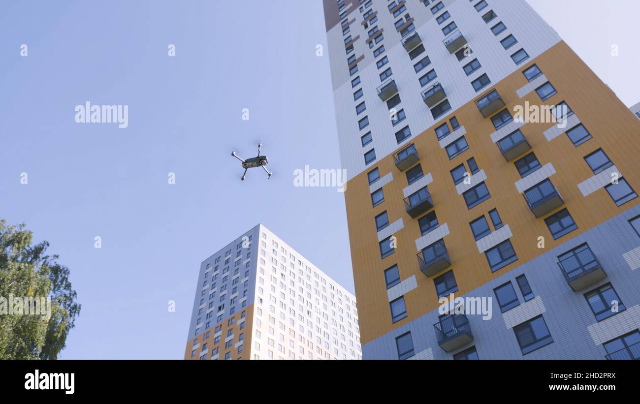 Flying drone on background of house. Action. Bottom view of first ...