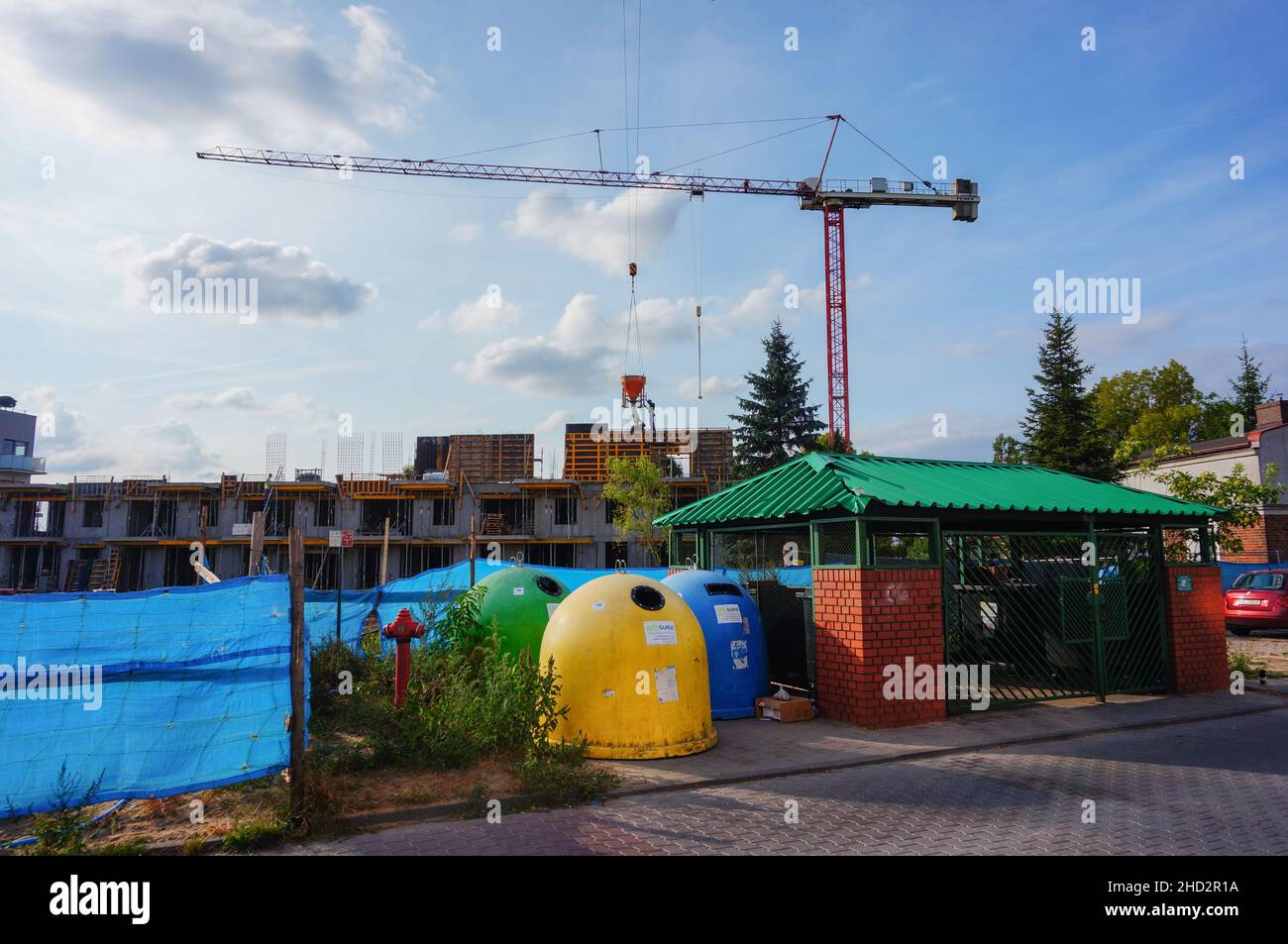 Trash containers in front of an apartment building under construction ...