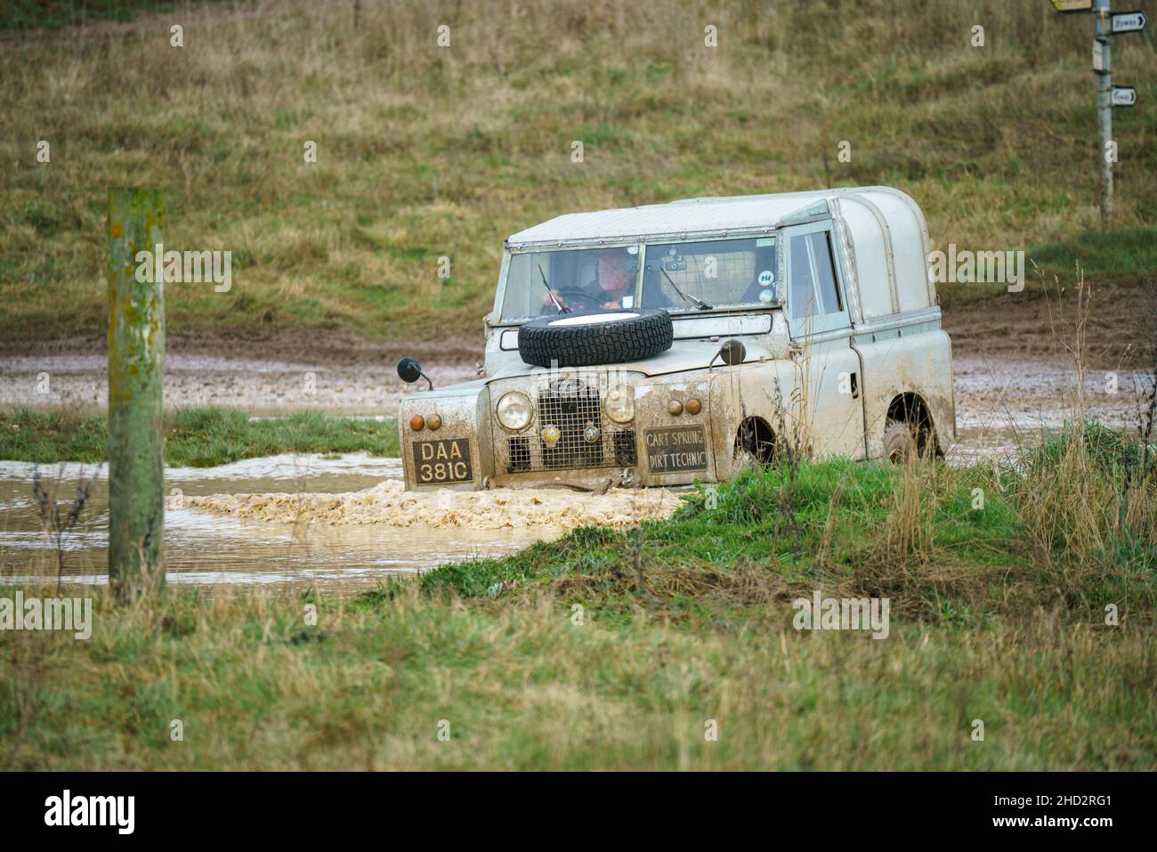 a vintage Land Rover series 2 vehicle driving off-road through deep ...