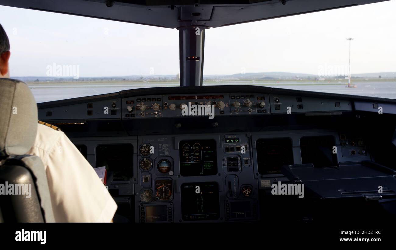 Rear view of pilot operating controls of corporate jet. Captain in the ...