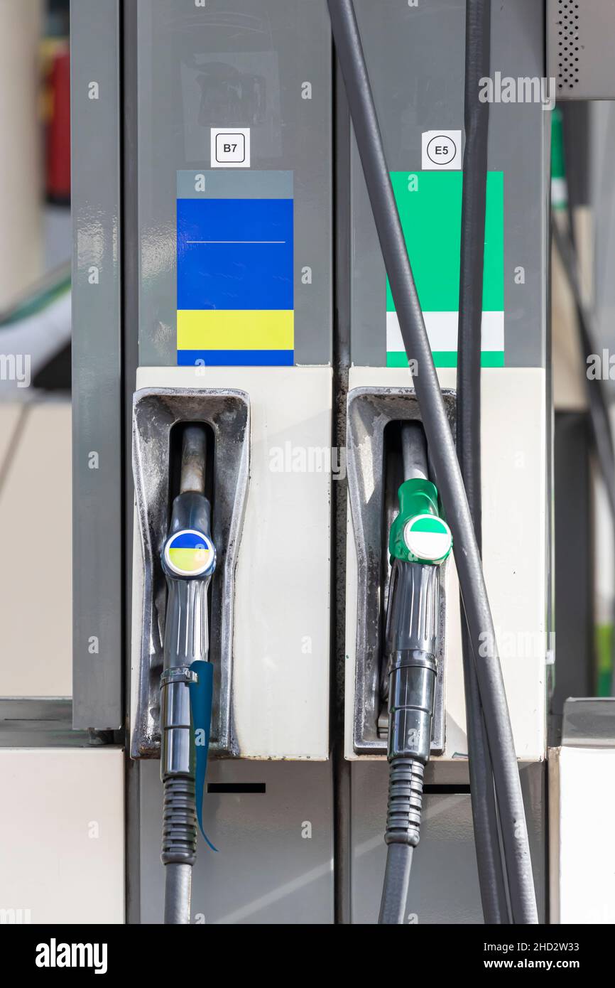 vertical view in foreground of two fuel pump guns, the increase in ...