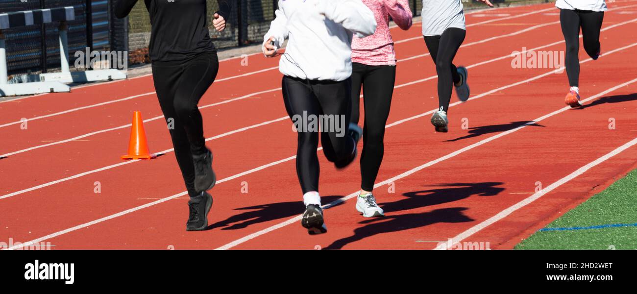 A group of high school girls running together on a track during track ...