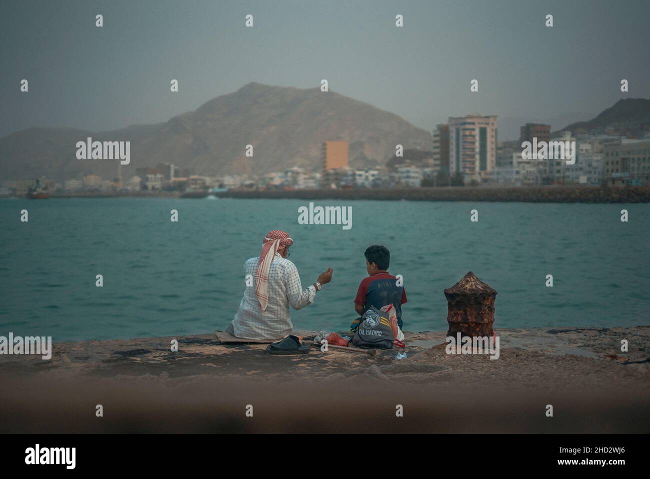 A fisherman accompanied by a granddaughter in the port of Mukalla ...