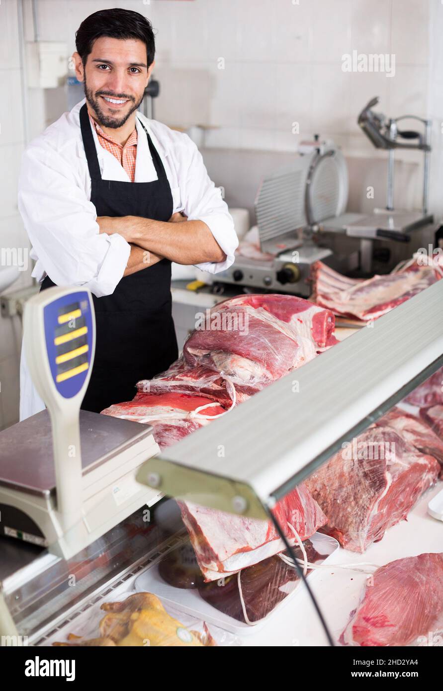 Portrait of adult male butcher who is offering meat Stock Photo - Alamy