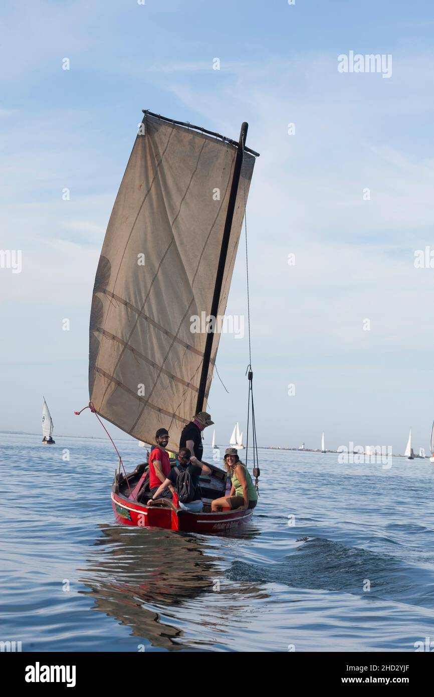 Three people sail in a traditional sailing boat through the Ria de ...