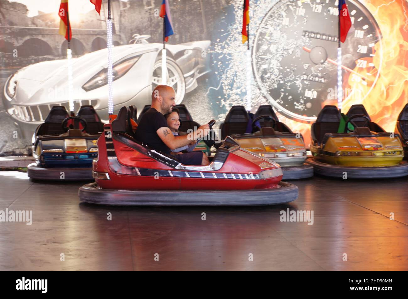 Man and young boy sitting in bump cars at a fair Stock Photo - Alamy