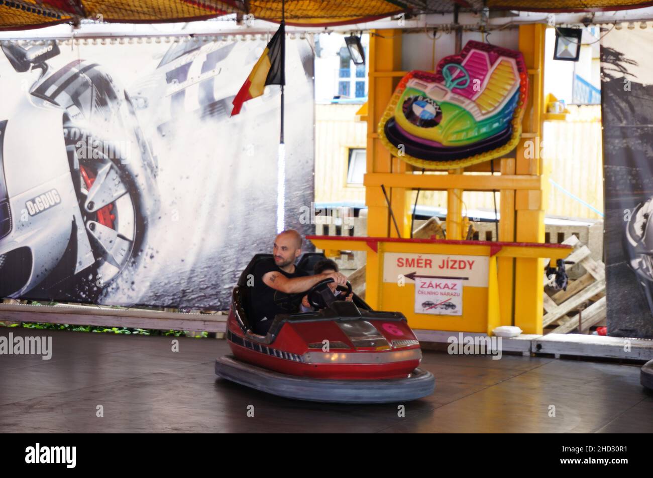 Man and young boy sitting in bump cars at a fair Stock Photo - Alamy