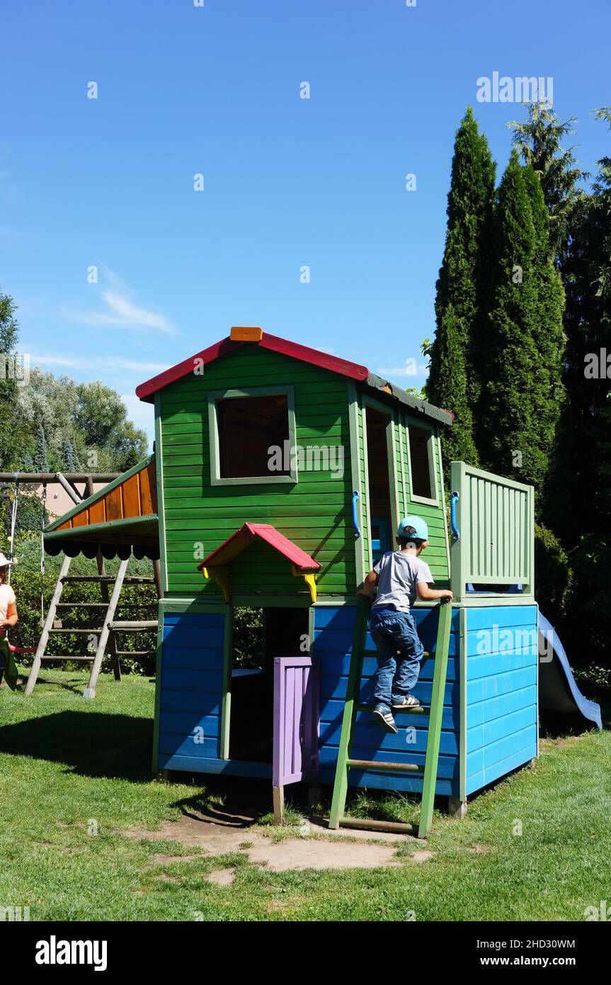 Children playing by a wooden green hut of a playground in Hortulus ...