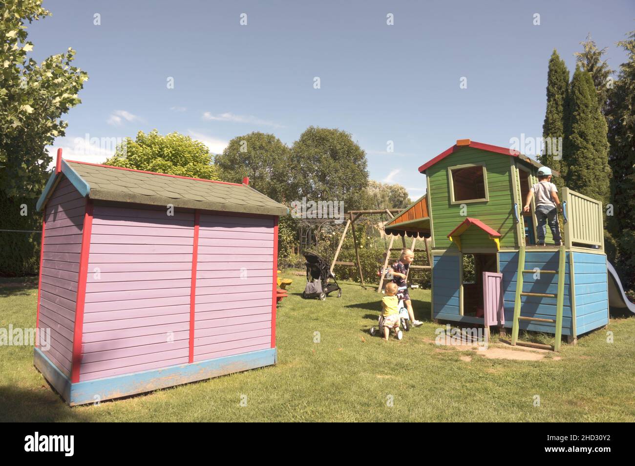 Children playing by a wooden green hut of a playground in Hortulus ...