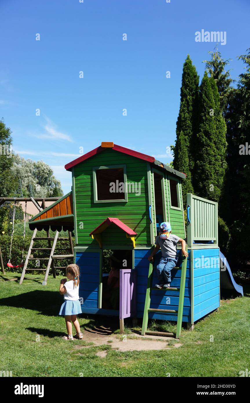 Children playing by a wooden green hut of a playground in Hortulus ...