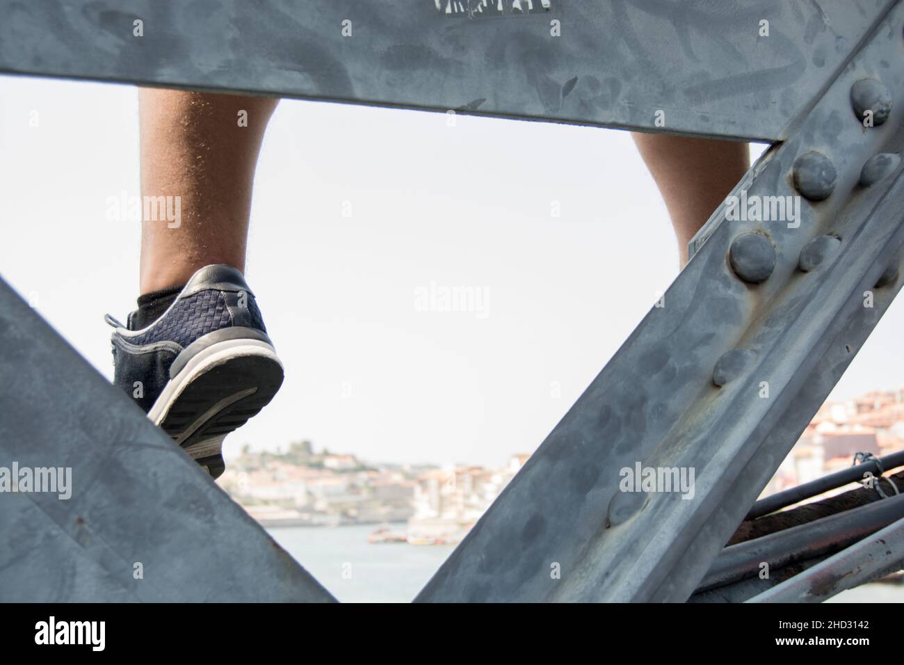 Shoes of a man sitting on a metal bridge Stock Photo - Alamy