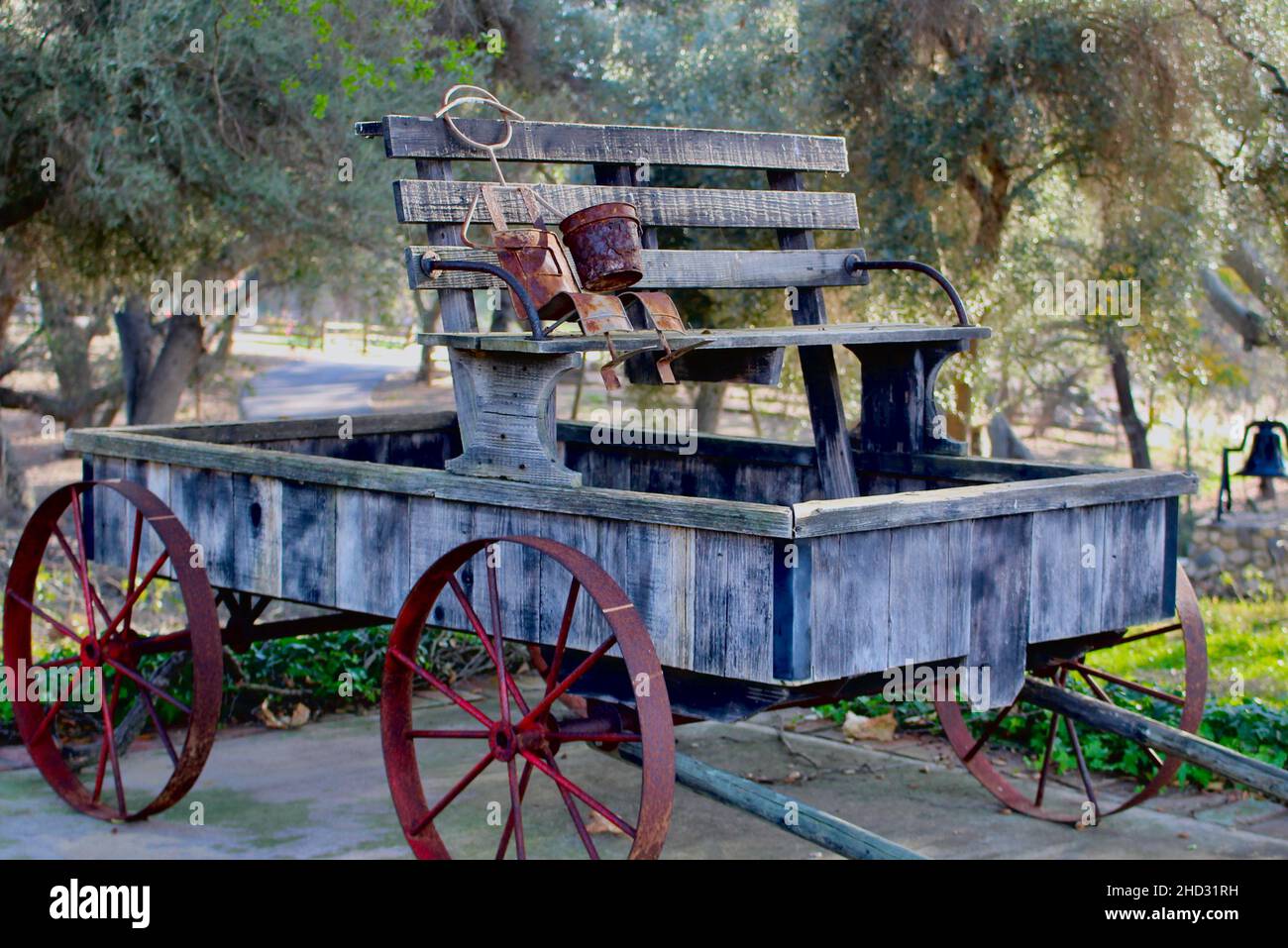 Old wooden farm wagon with red iron wheels and weathered bench seat ...