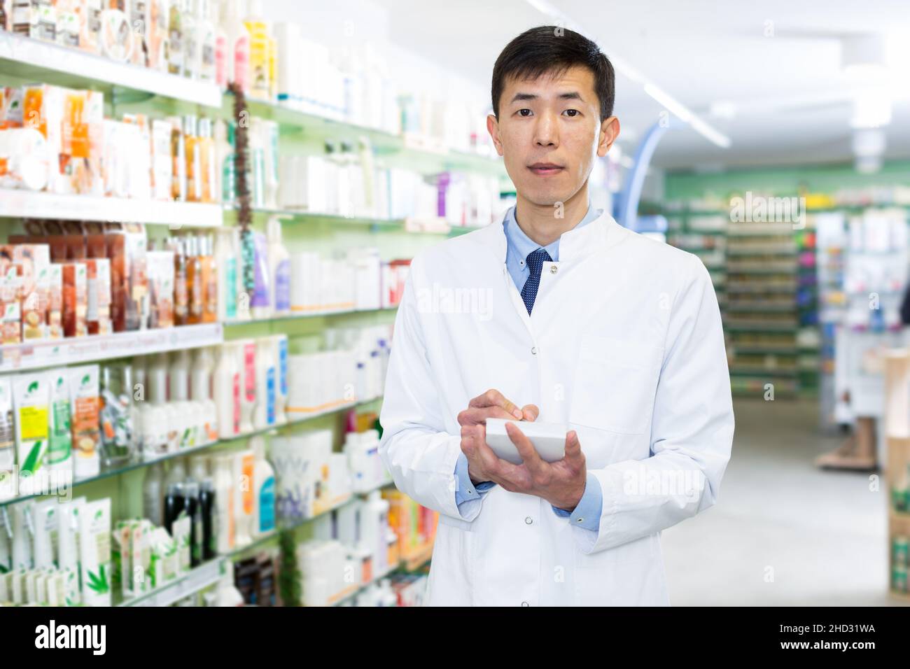 Chinese man pharmacist is attentively checking medicine in pharmacy ...