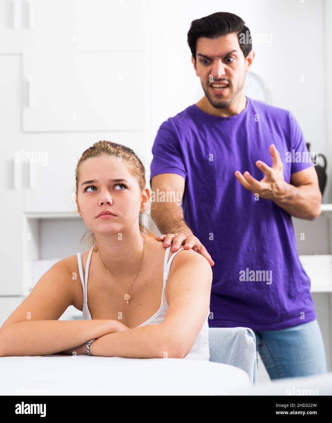 Upset woman at table with disgruntled man behind Stock Photo - Alamy