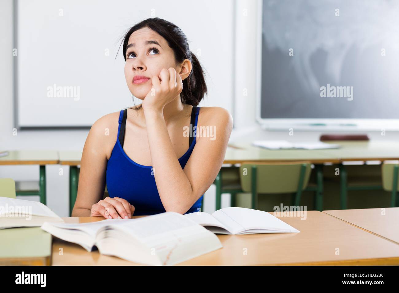 Portrait schoolgirl who is solving a difficult task at the desk Stock ...