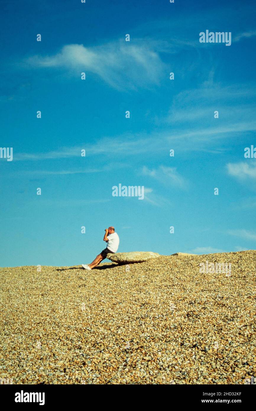 Print ready landscape of Eastbourne shingle beach with colourful boat, sunshine and sunny blue ...