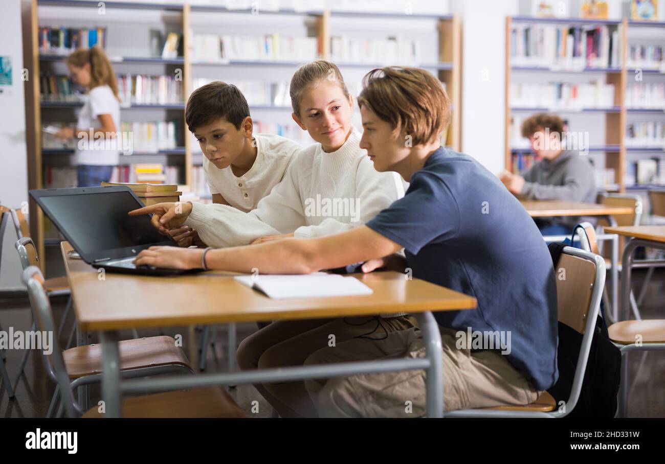 Teenage students working in groups in library Stock Photo - Alamy