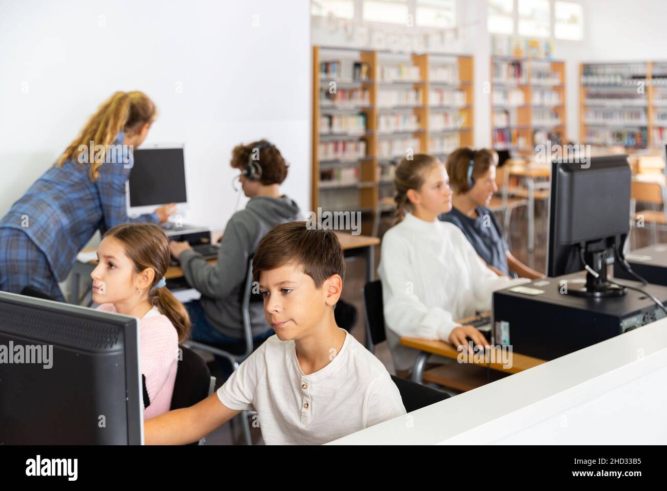 Young boys and girls using computers in library Stock Photo - Alamy