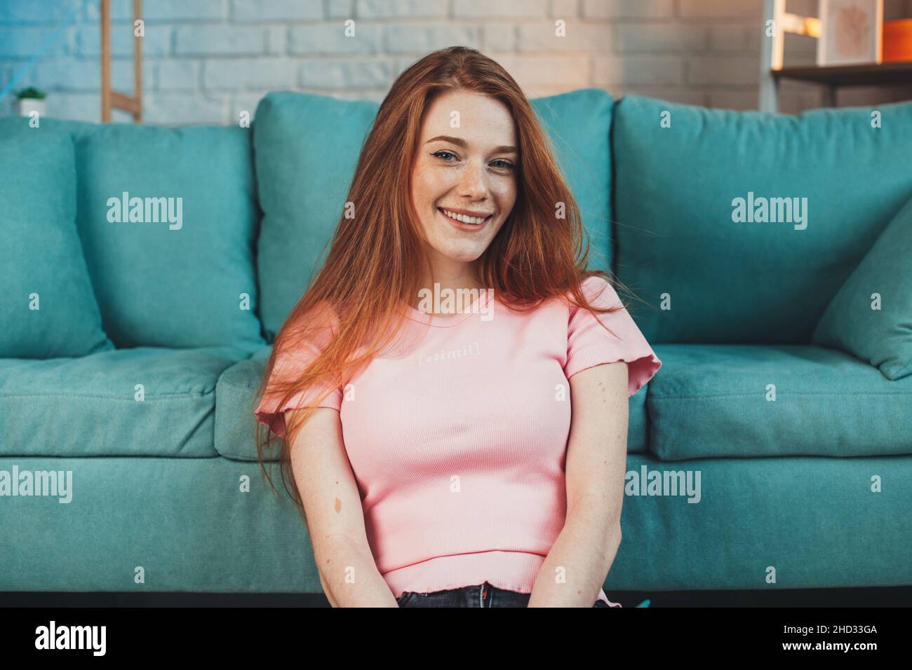 Portrait of a girl looking at the camera smiling while sitting down ...