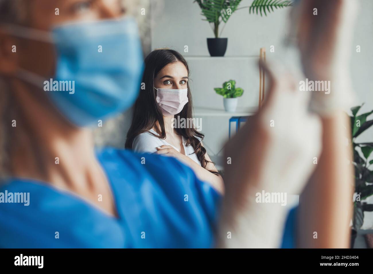 Nurse wearing facial mask and holding syringe of covid-19 vaccine in ...