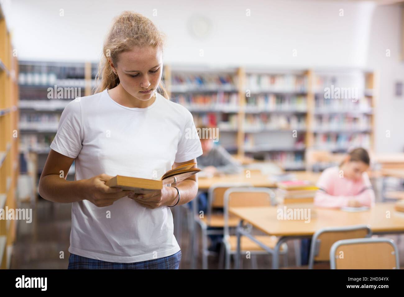 Teenager girl in library Stock Photo - Alamy