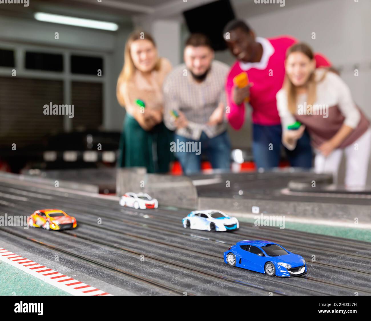 Slot car racing track. Emotional players drive toy cars Stock Photo - Alamy