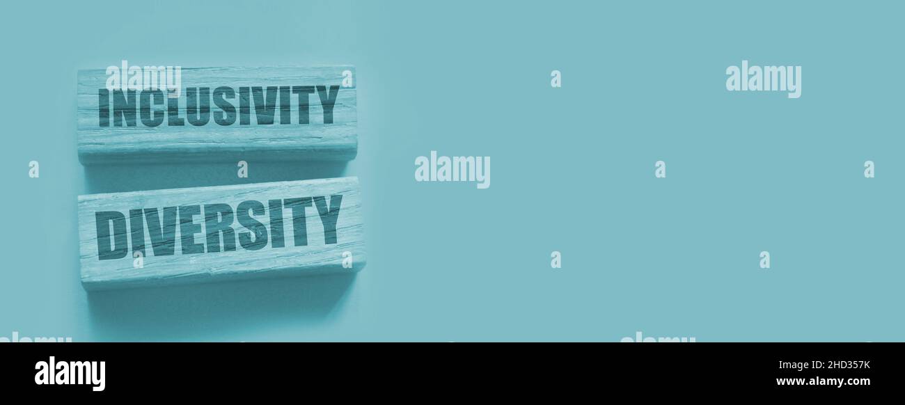 Inclusivity diversity words on wooden block on the yellow background ...