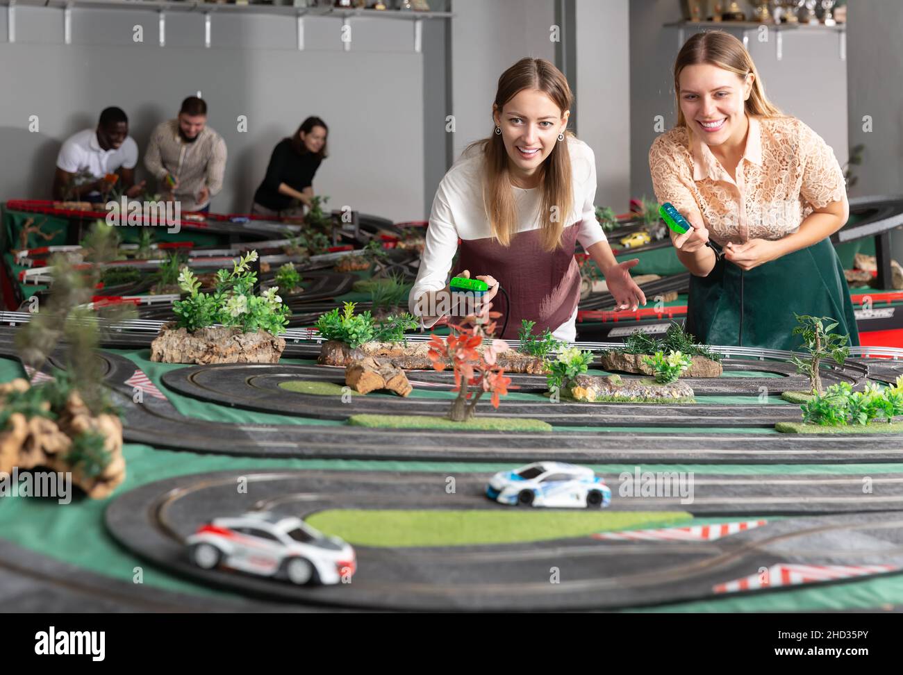 Portrait of two girls playing with slot car racing track Stock Photo ...