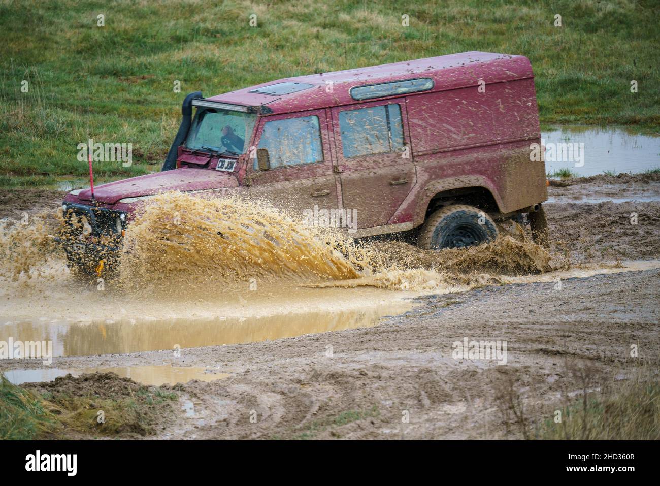a Land Rover 110 LWB vehicle driving off-road through deep muddy water ...