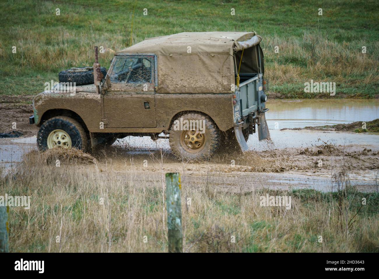 a Land Rover vehicle driving off-road through deep muddy water ...