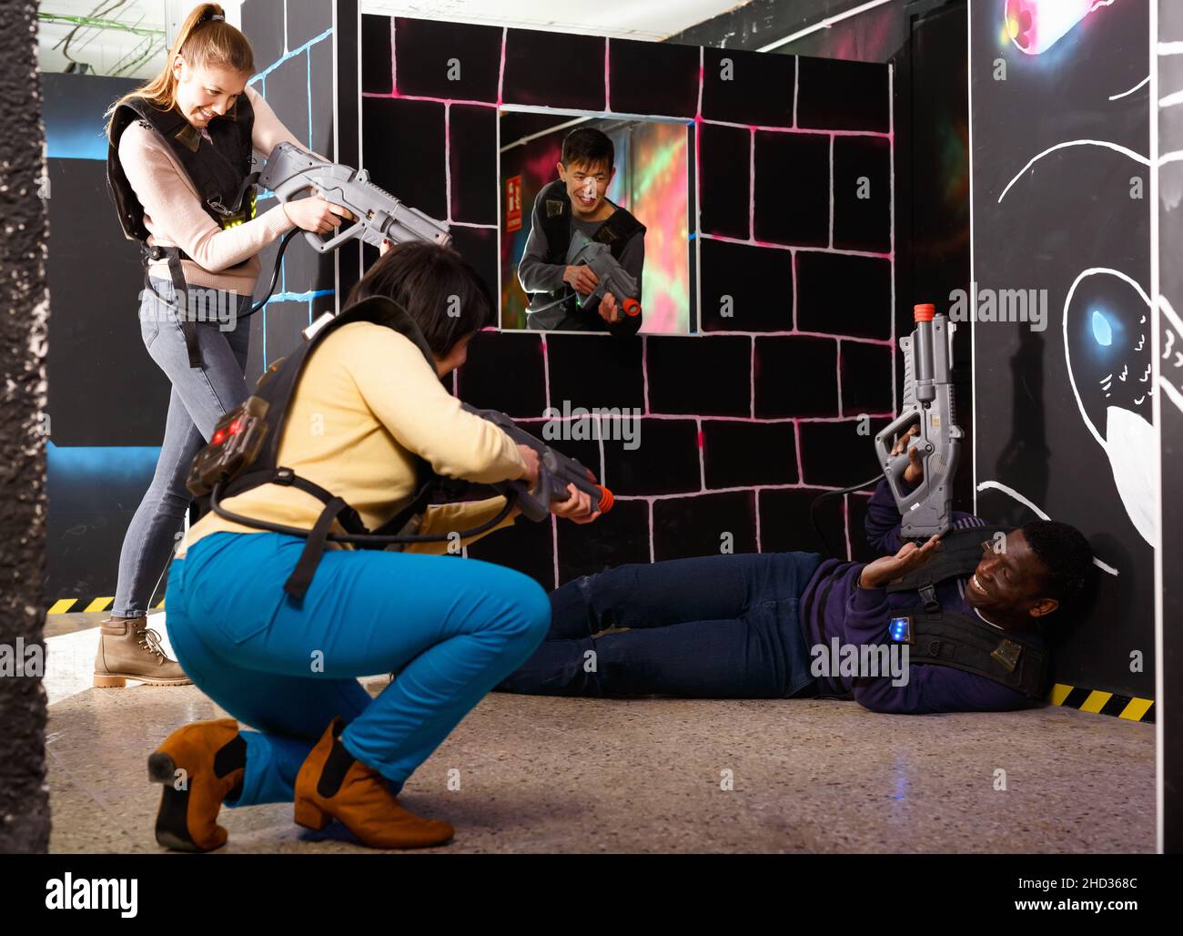 Modern people of different nationalities with laser pistols playing ...