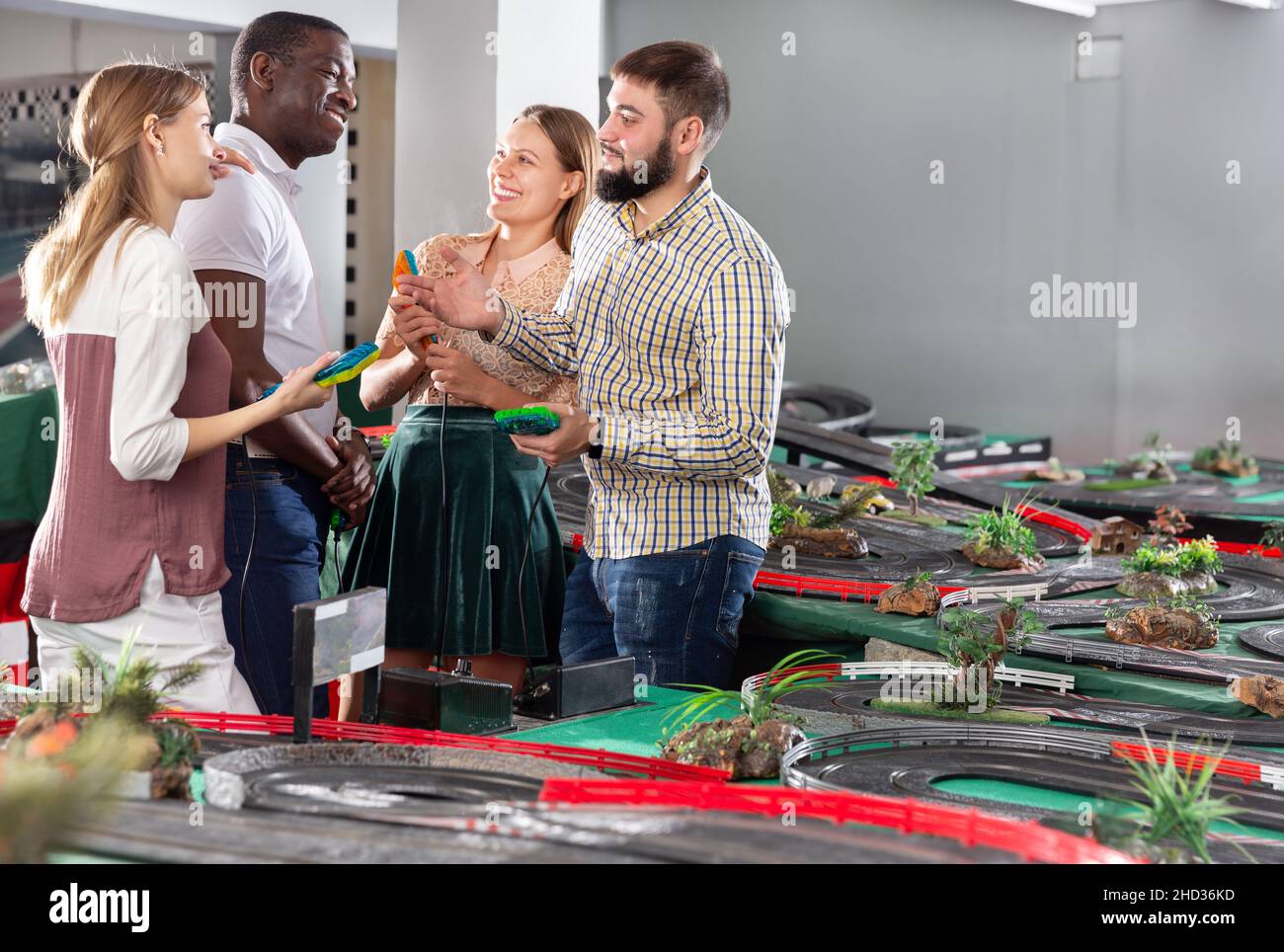 Friends discuss the game with models of race cars Stock Photo - Alamy