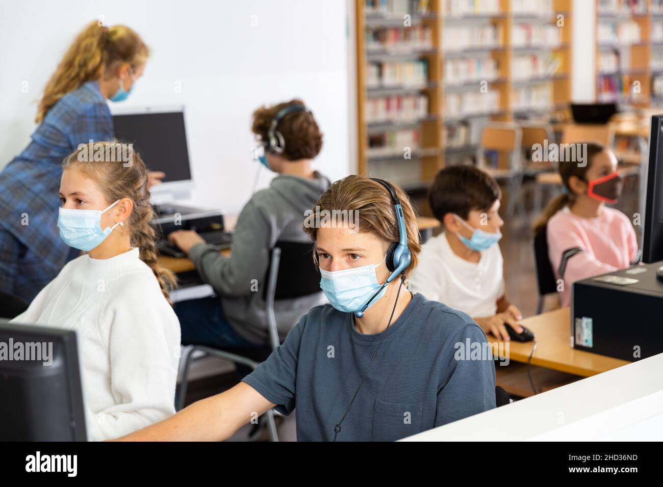 Focused schoolchildren in masks at the computer Stock Photo - Alamy