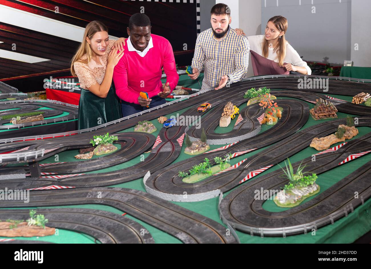 Two teams from friends play slot car racing game Stock Photo - Alamy